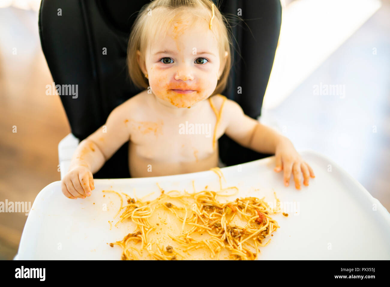 Little b eating her dinner and making a mess Stock Photo - Alamy