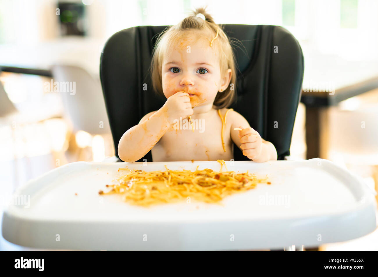 Little b eating her dinner and making a mess Stock Photo - Alamy