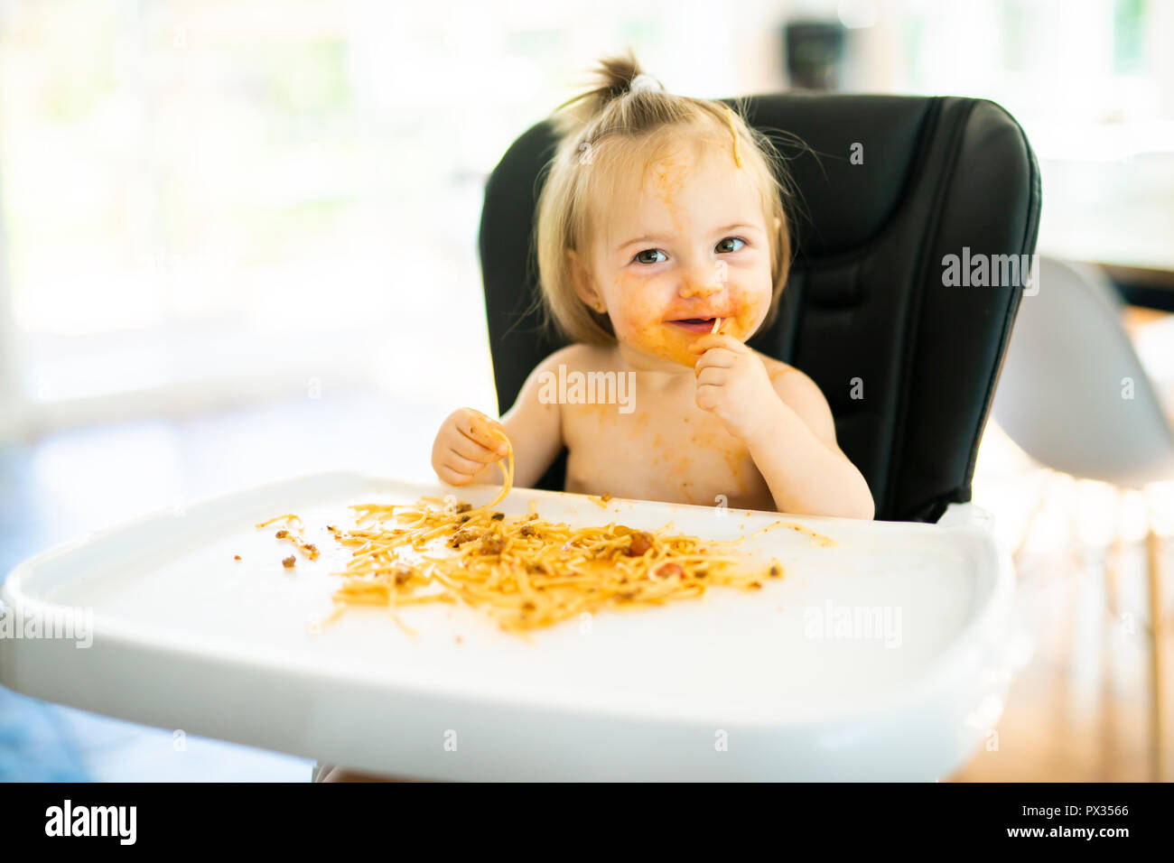 Little b eating her dinner and making a mess Stock Photo - Alamy