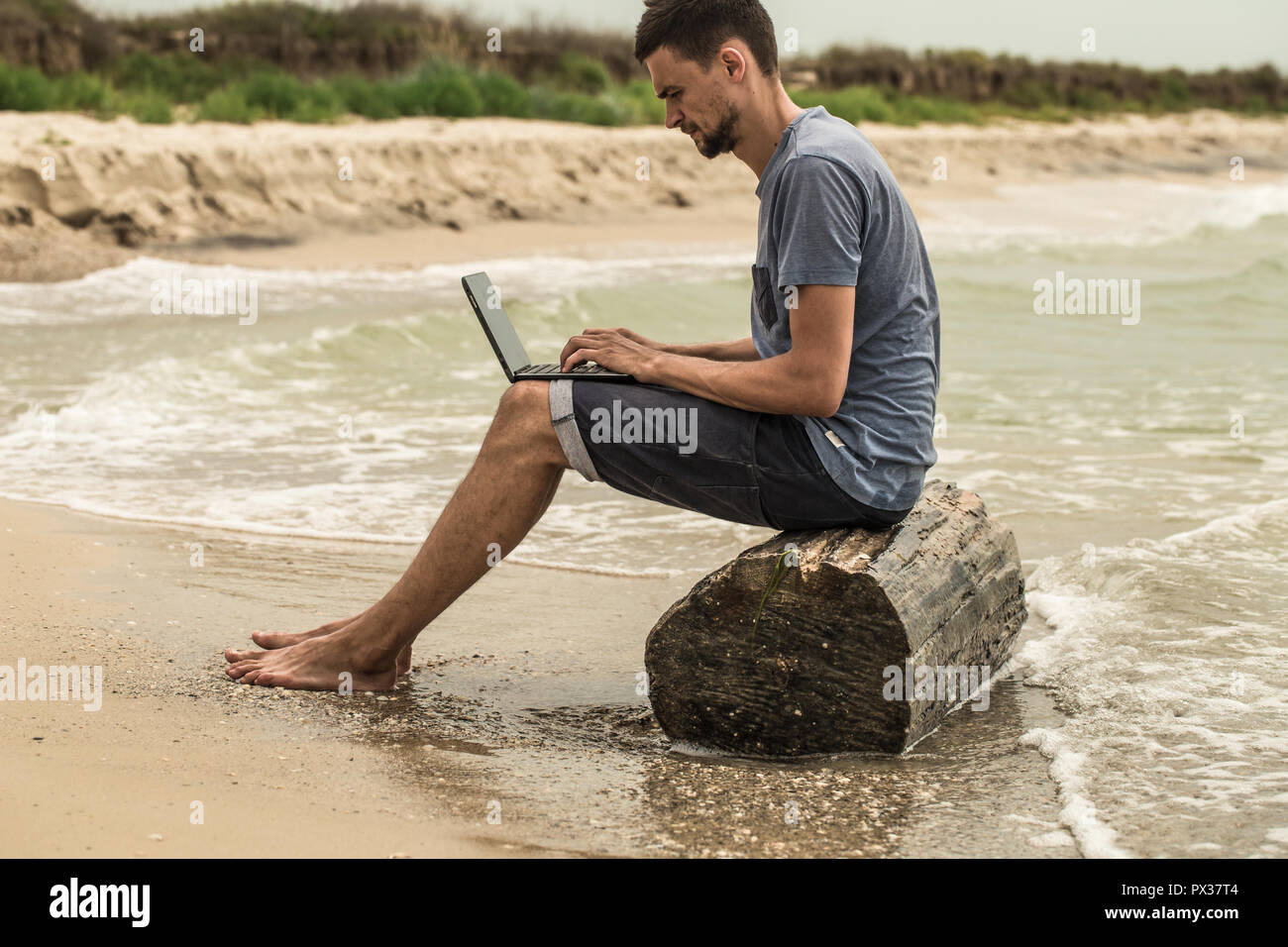 the man working at a computer in nature, work on the beach Stock Photo ...