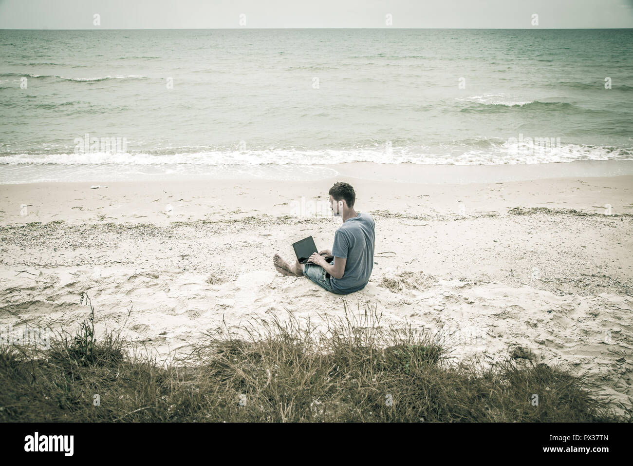 man running on the computer, in nature, to work on the beach Stock ...