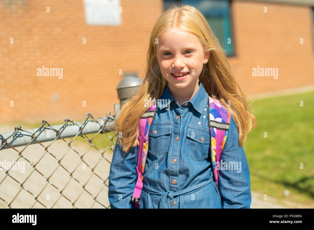 A Portrait of cute girl with backpack outside of school Stock Photo - Alamy
