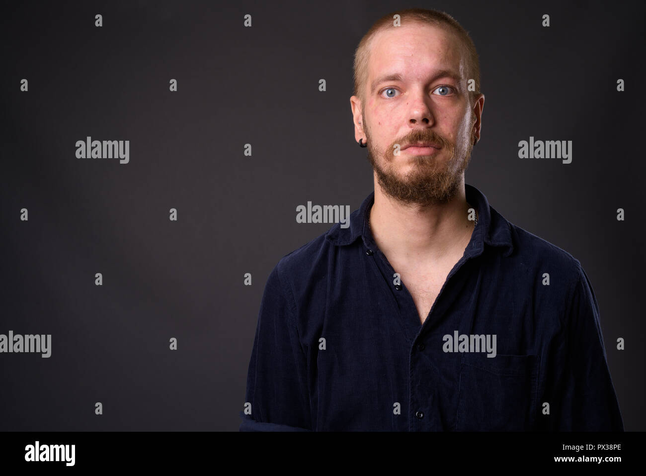 Portrait of man against gray studio background Stock Photo - Alamy