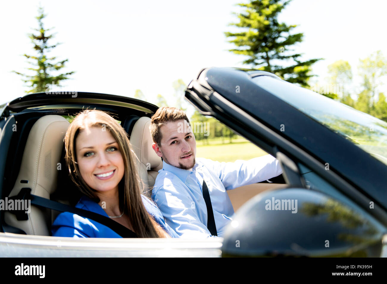 Couple enjoying a drive in a convertible Stock Photo - Alamy