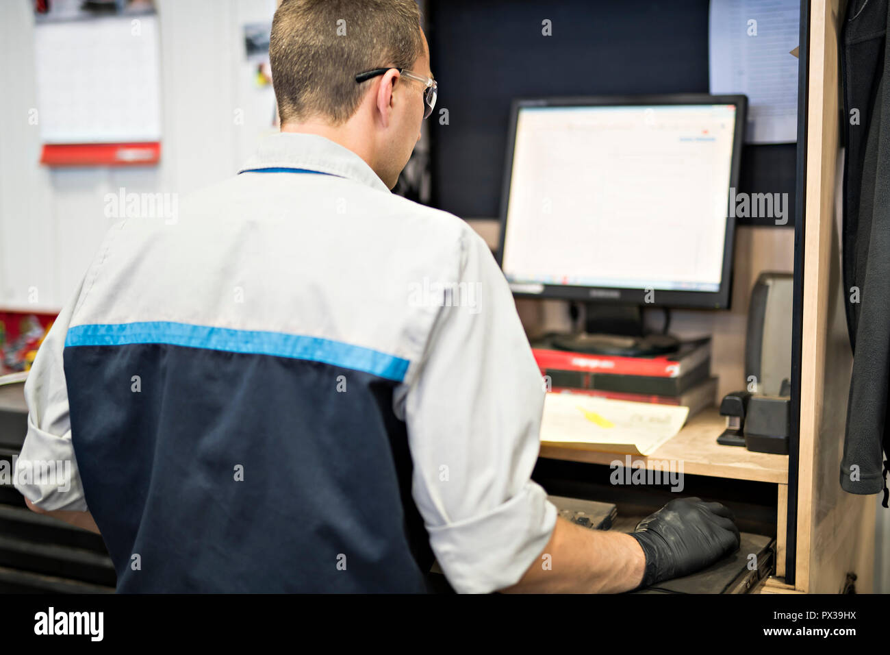 Professional car mechanic working in auto repair service using computer ...