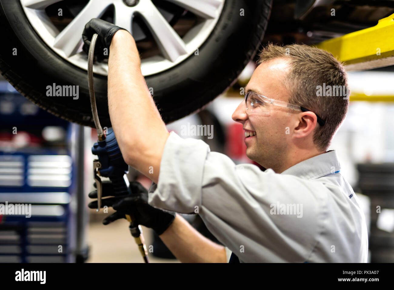 Handsome mechanic job in uniform working on car Stock Photo - Alamy