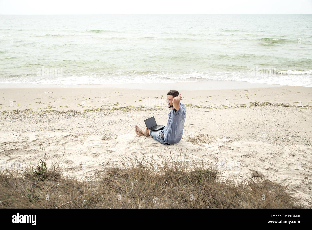 man running on the computer, in nature, to work on the beach Stock ...