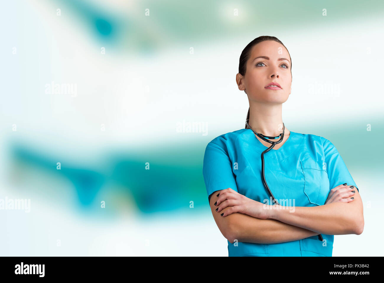 beautiful woman nurse or doctor with crossed arms in front of a blurry ...