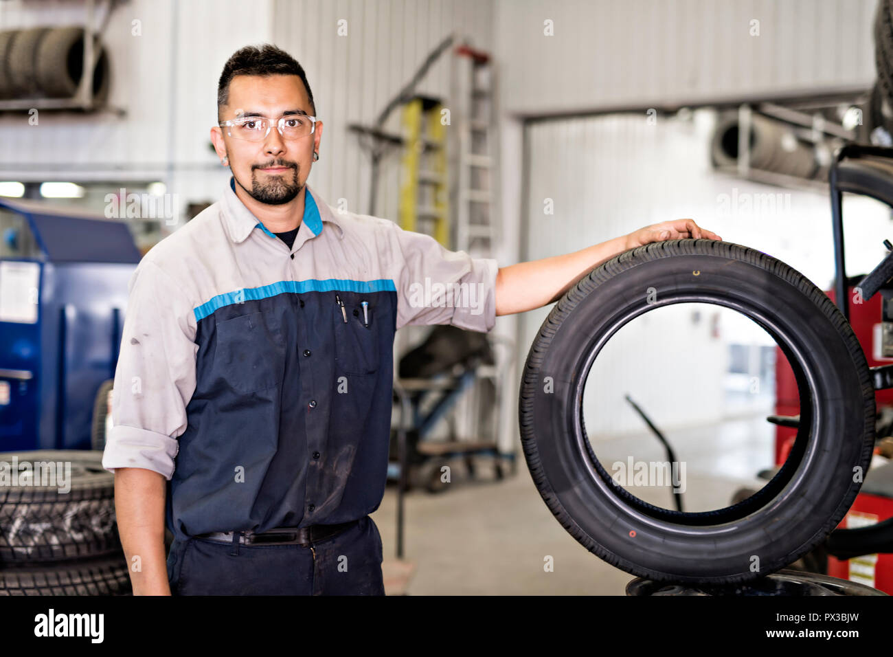 Mechanic changing car tire at work Stock Photo - Alamy