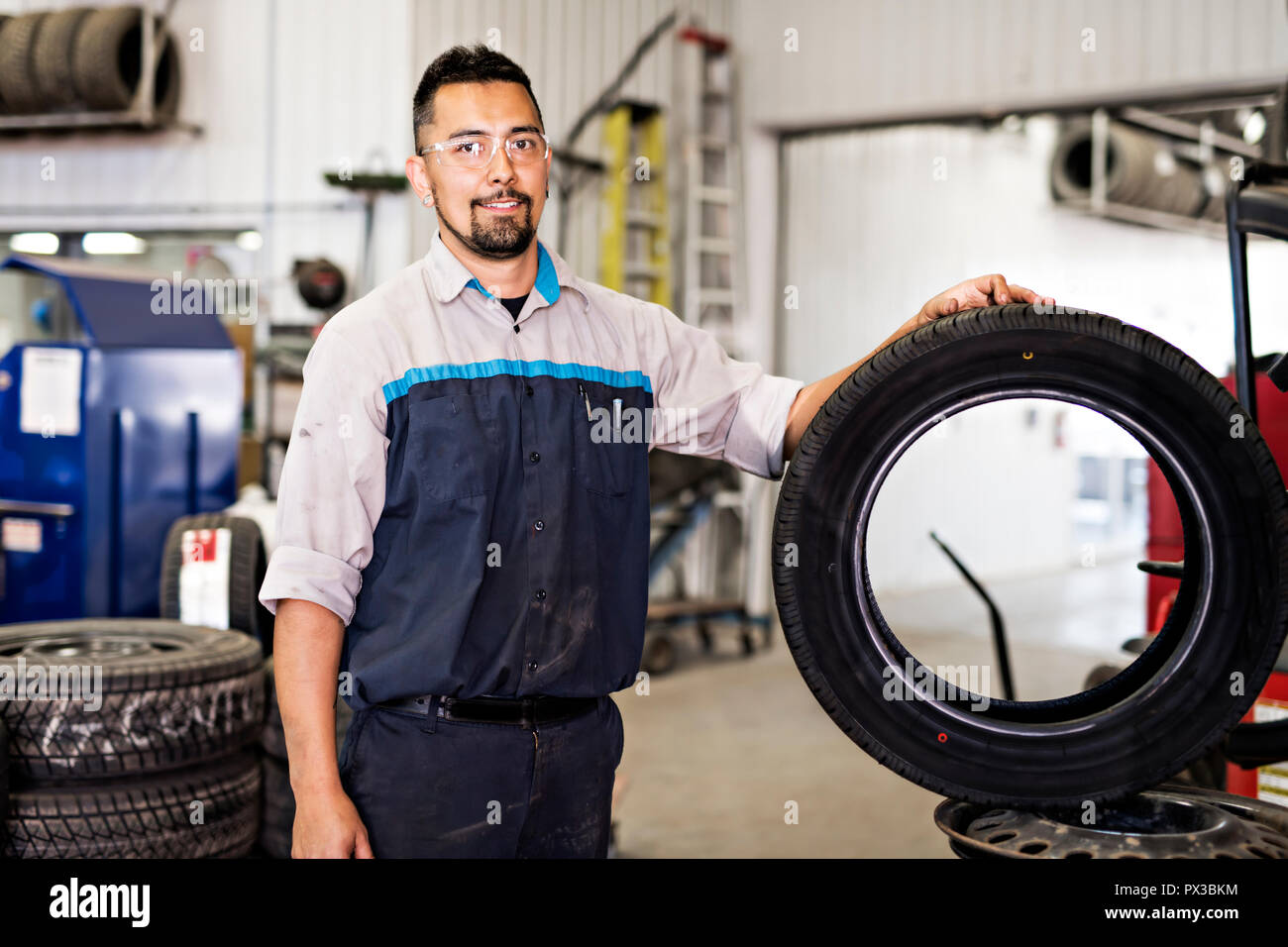 Mechanic changing car tire at work Stock Photo - Alamy