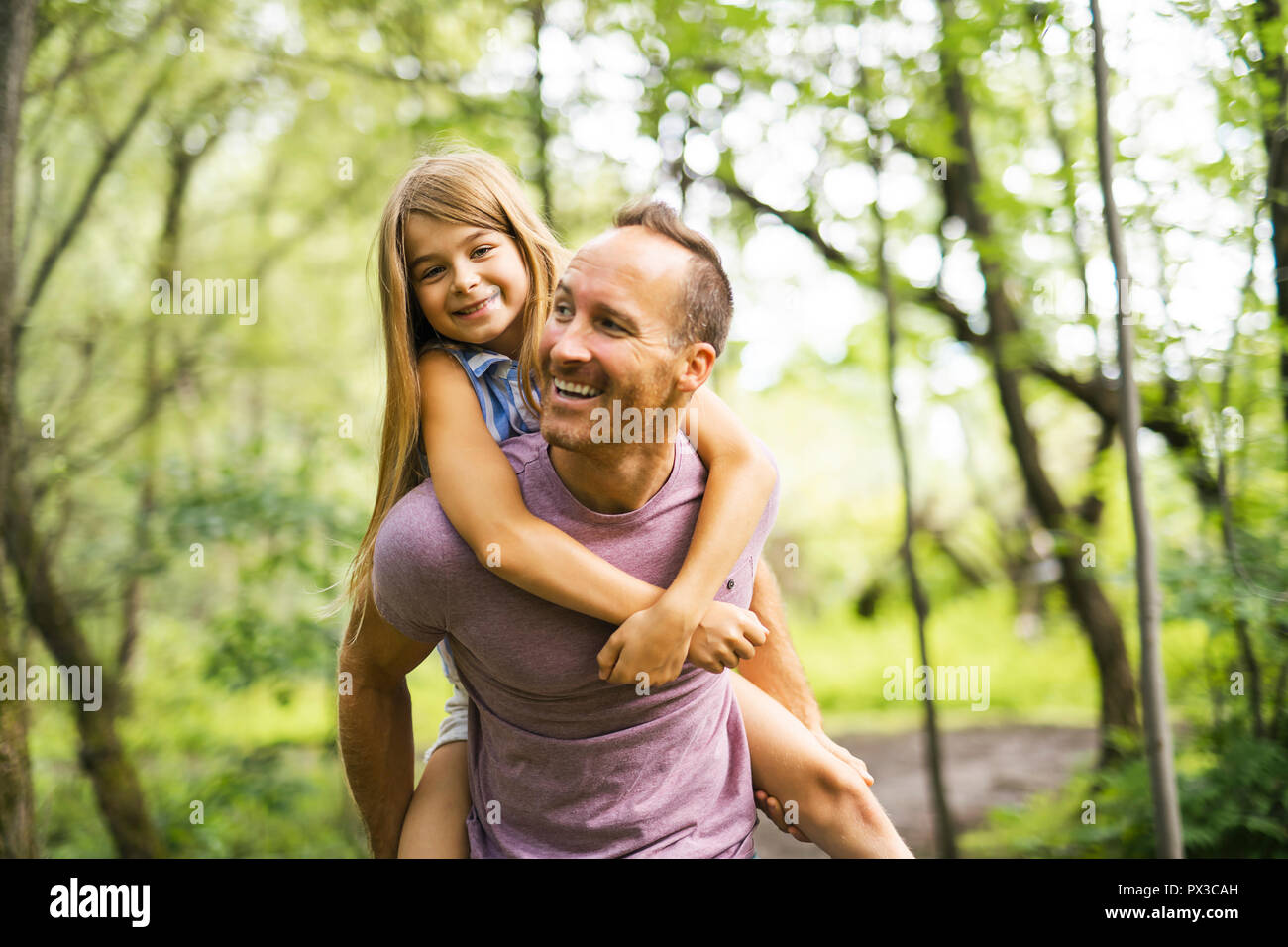 Father giving his daughter a piggyback ride, having fun Stock Photo - Alamy