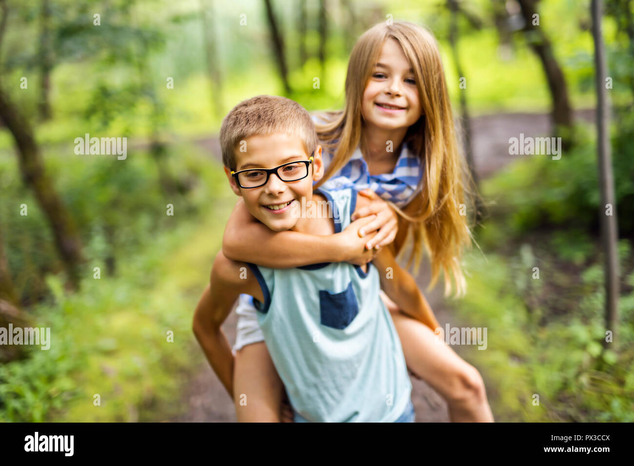 brother and sister giving piggyback in forest Stock Photo - Alamy
