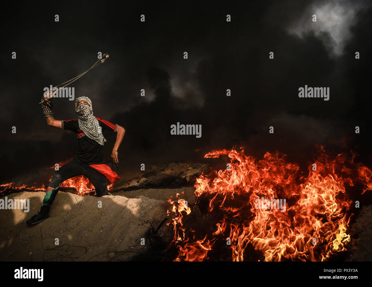 A Palestinian protester seen throwing a stone towards the Israeli ...