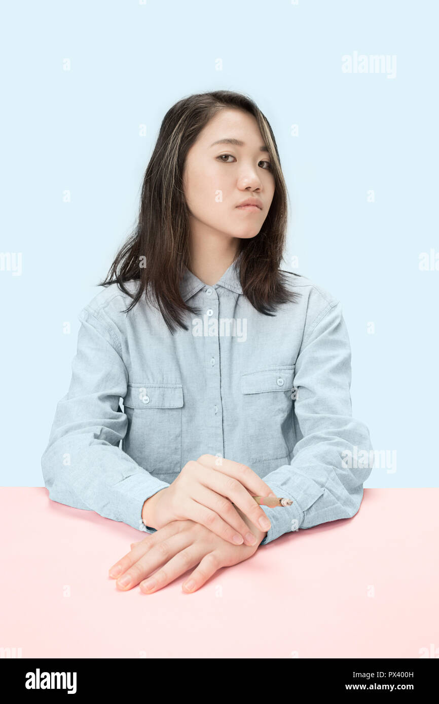 Handsome young korean women smoking cigar while sitting at table at ...