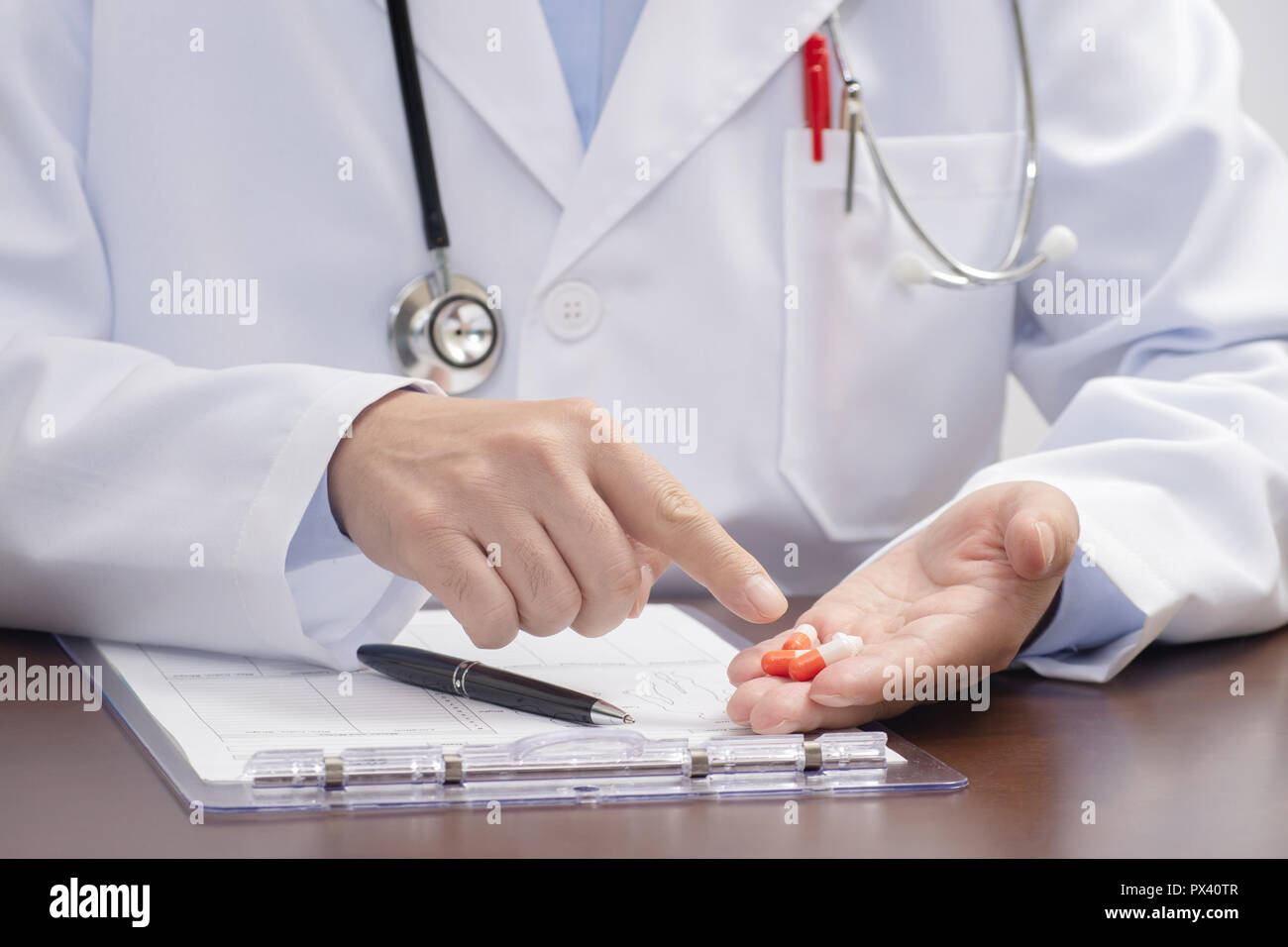 A male doctor putting medication on the palm of hand and explaining ...