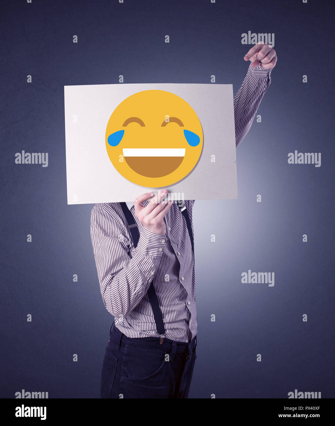 Young businessman hiding behind a laughing emoticon on cardboard Stock ...