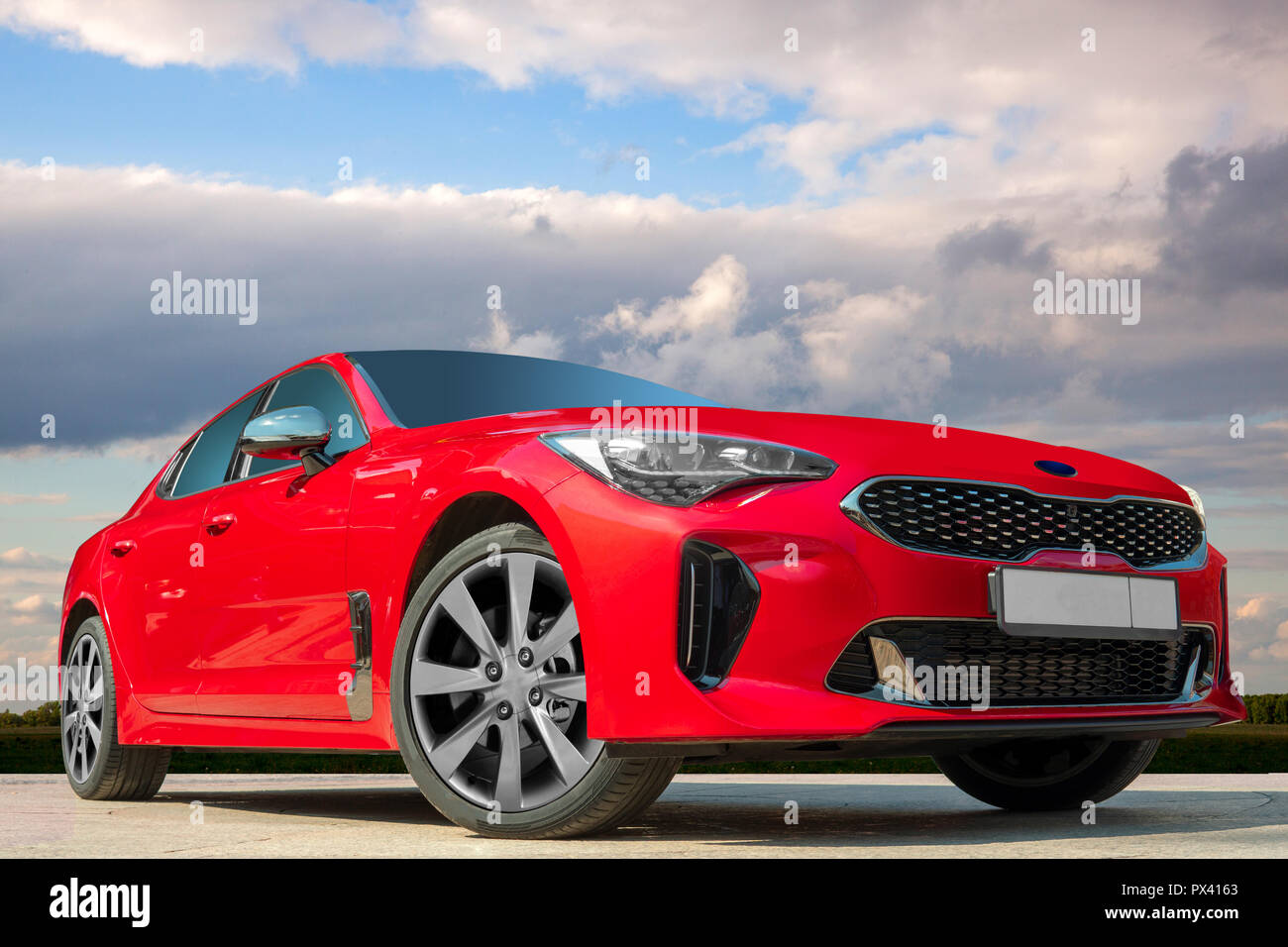 Red car on a blue sky background with white clouds. A stylish, modern ...