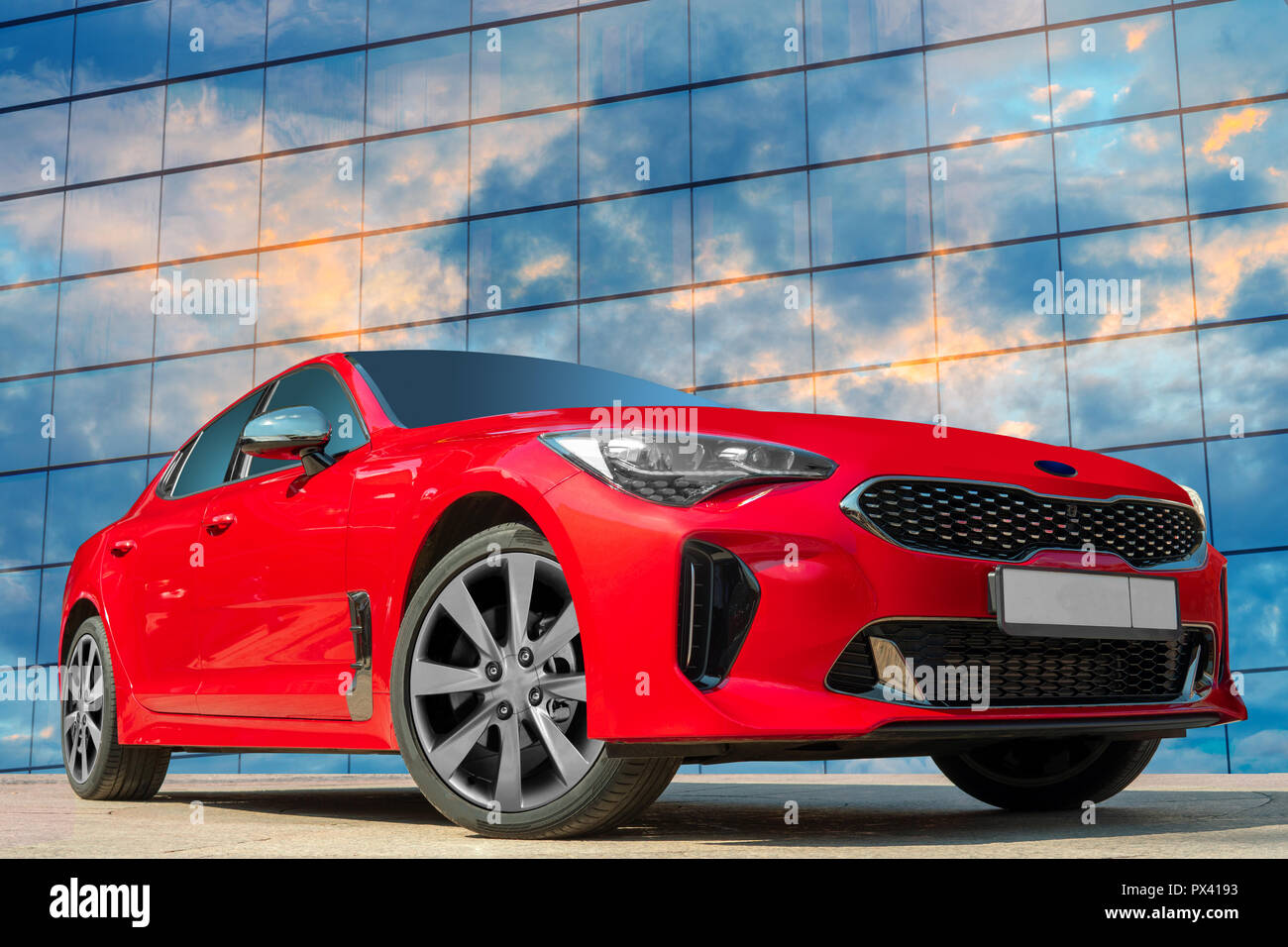 Red car against the background of the evening sky. Stylish, modern ...
