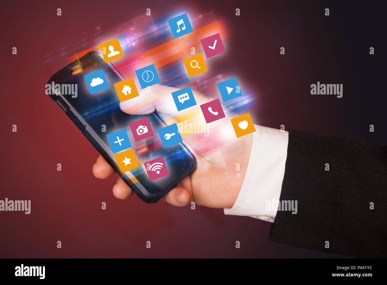 Hand using phone with colorful fast moving application icons and ...