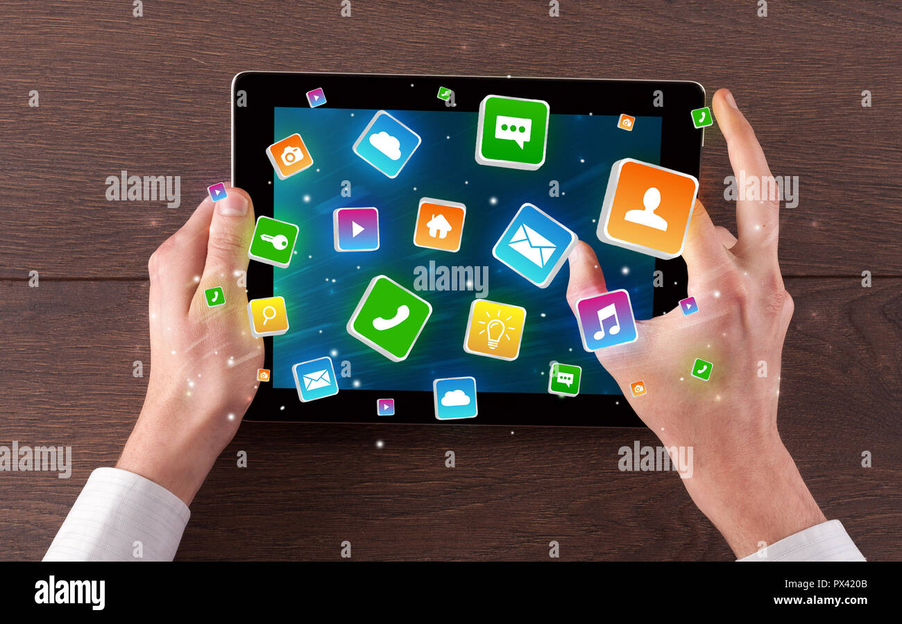 Hand using tablet with colourfull bounce application symbols and icons ...