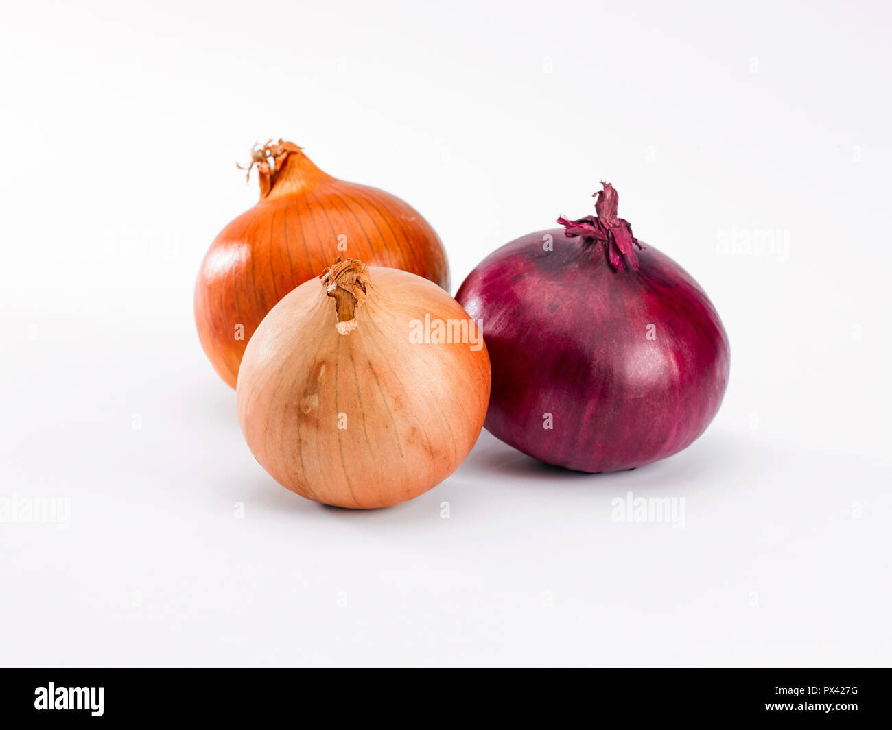three onions on a white background Stock Photo - Alamy
