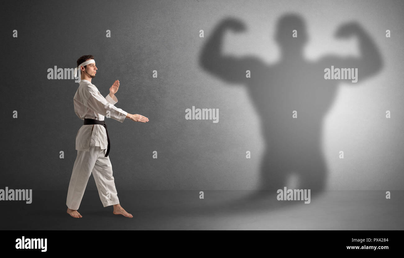 Young karate man fighting with a big black scary shadow Stock Photo - Alamy