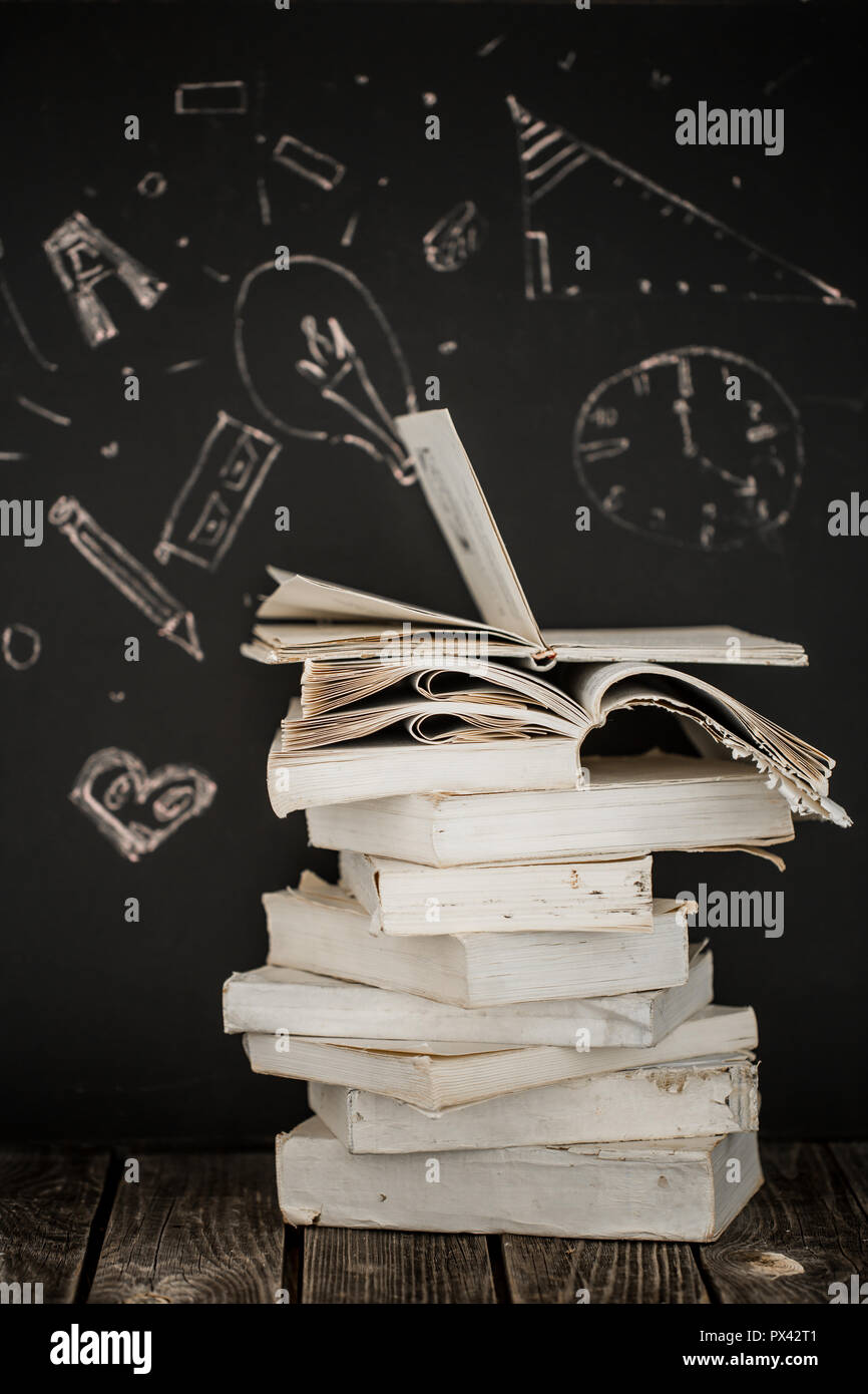 Back to school, stack of books and school supplies on blackboard ...