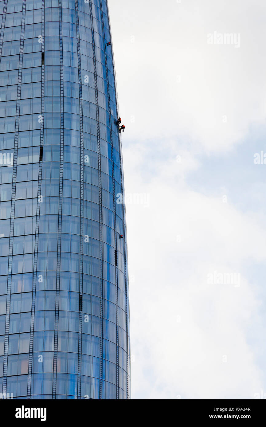 Maintenance operatives or window cleaners working from ropes on the ...