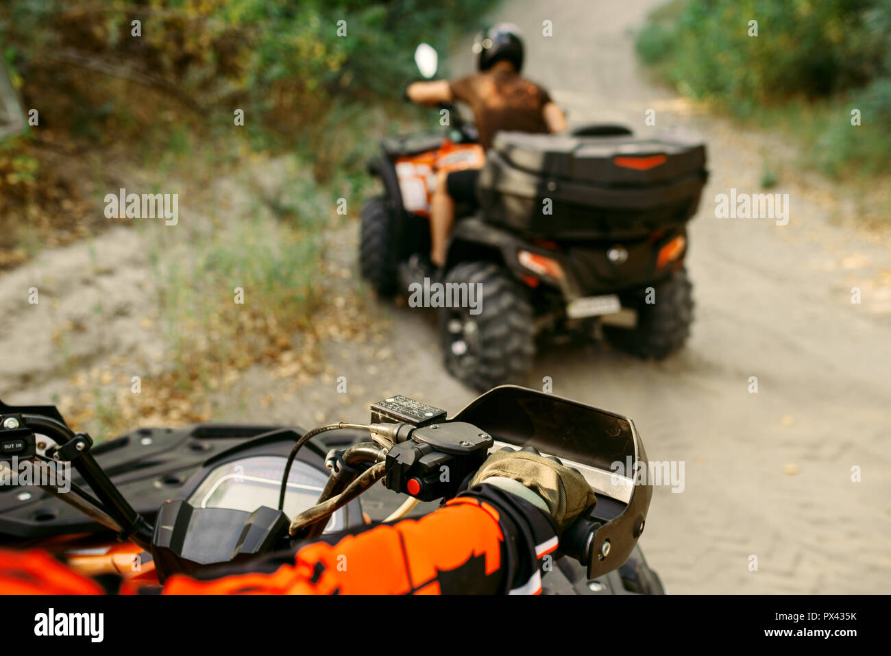 Two quad bike riders travels in forest, front view Stock Photo - Alamy