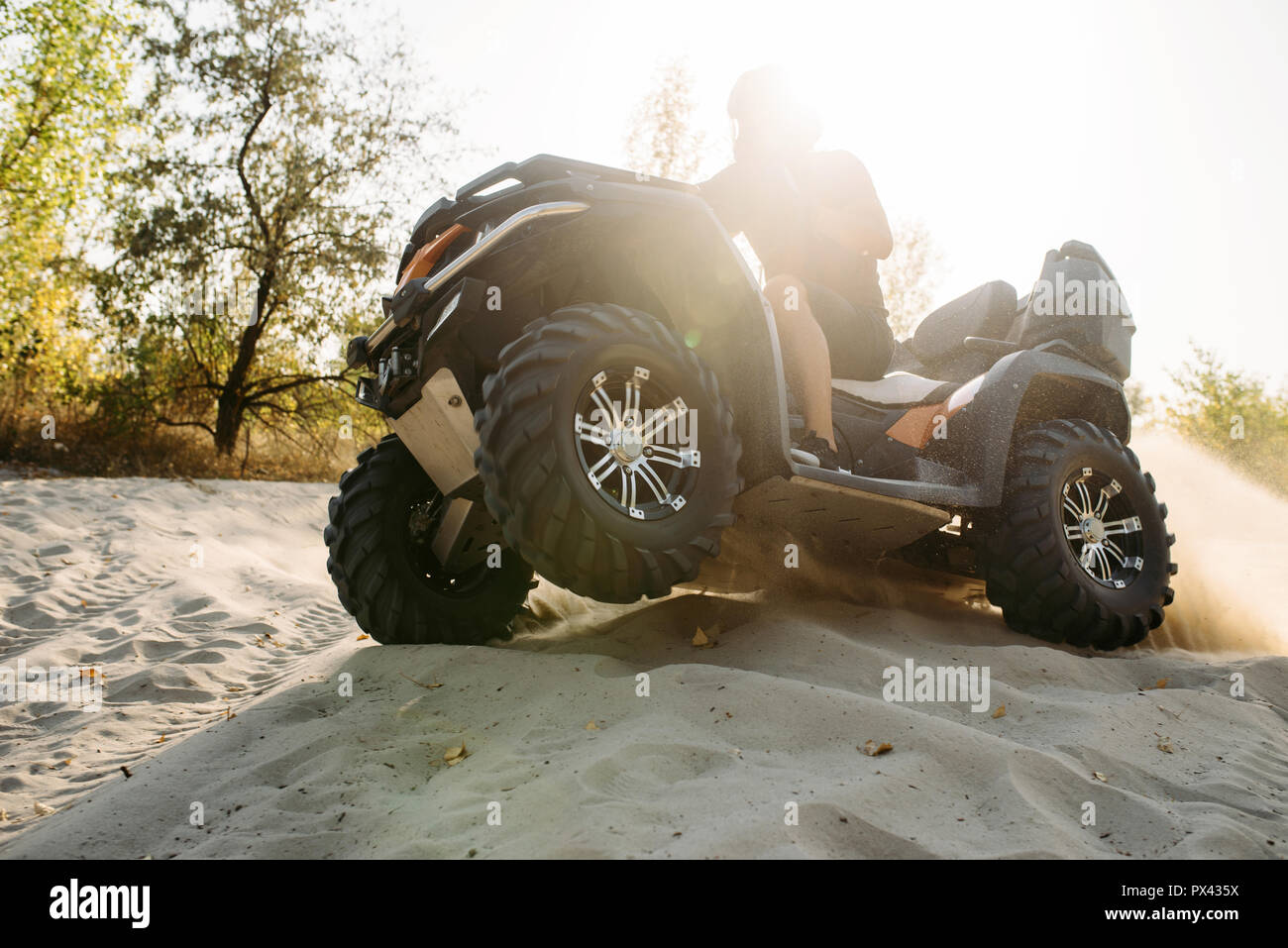 Atv rider in helmet climbing sandy road in forest Stock Photo - Alamy