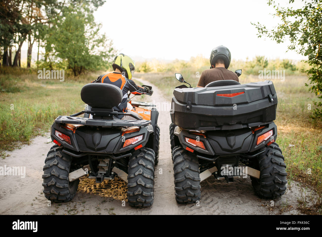 Two atv riders in helmets, back view, quad bike Stock Photo - Alamy