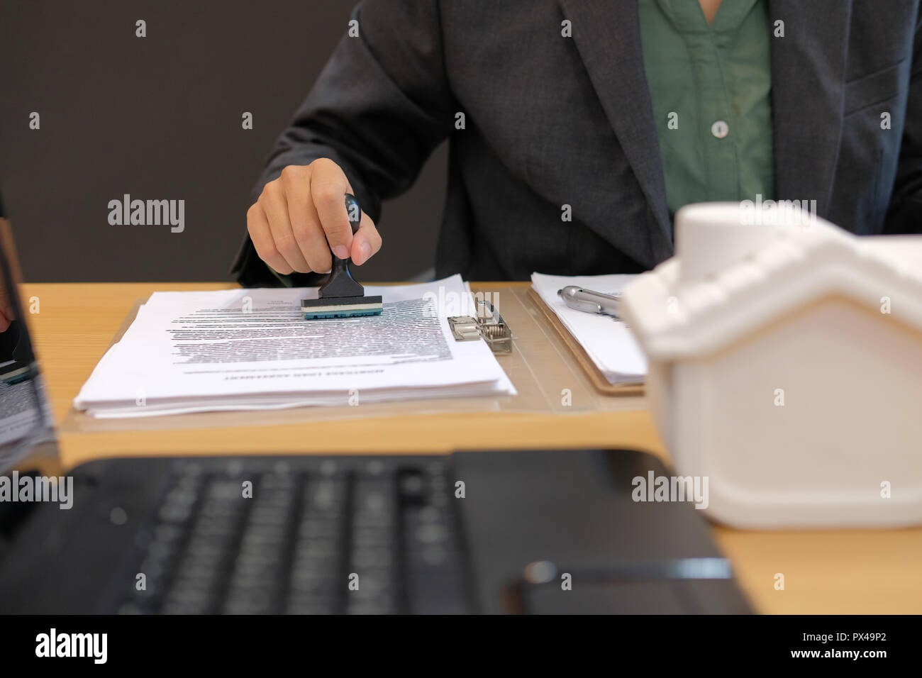 real estate agent using stamper for stamping approved on mortgage loan ...