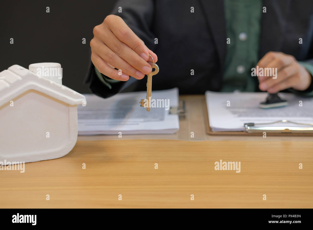 real estate agent with house key using stamper for stamping approved on ...
