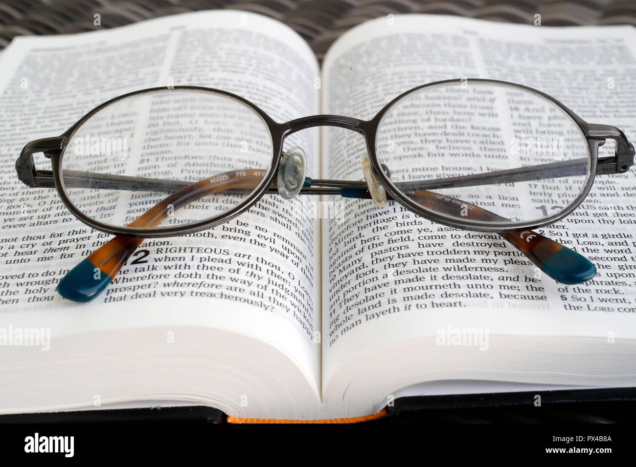 Pair of glasses on an open Bible Stock Photo - Alamy