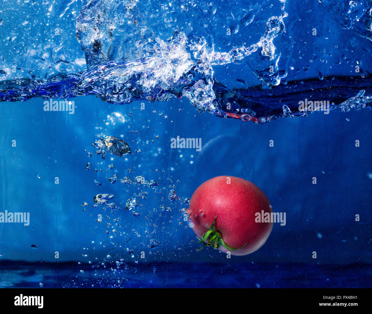 tomato falling into the water with splash Stock Photo - Alamy