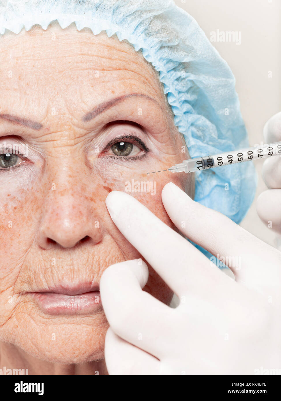 The surgeon doing skin check on mid age woman before plastic surgery ...