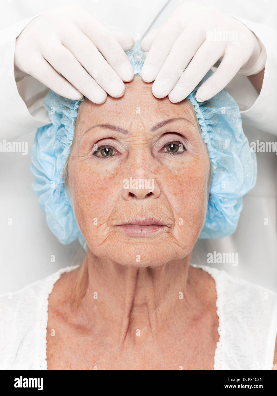 The surgeon doing skin check on mid age woman before plastic surgery ...