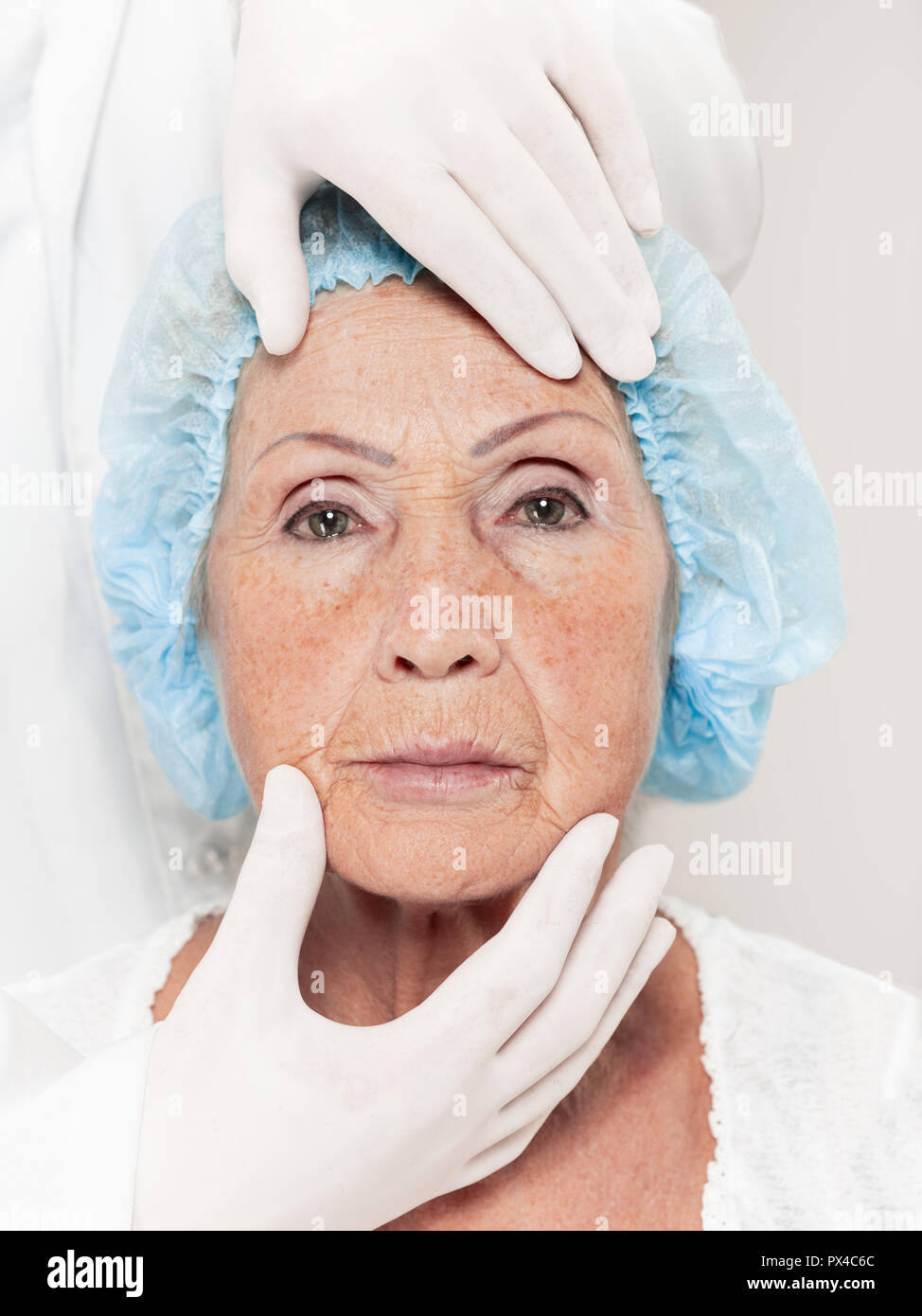 The surgeon doing skin check on mid age woman before plastic surgery ...