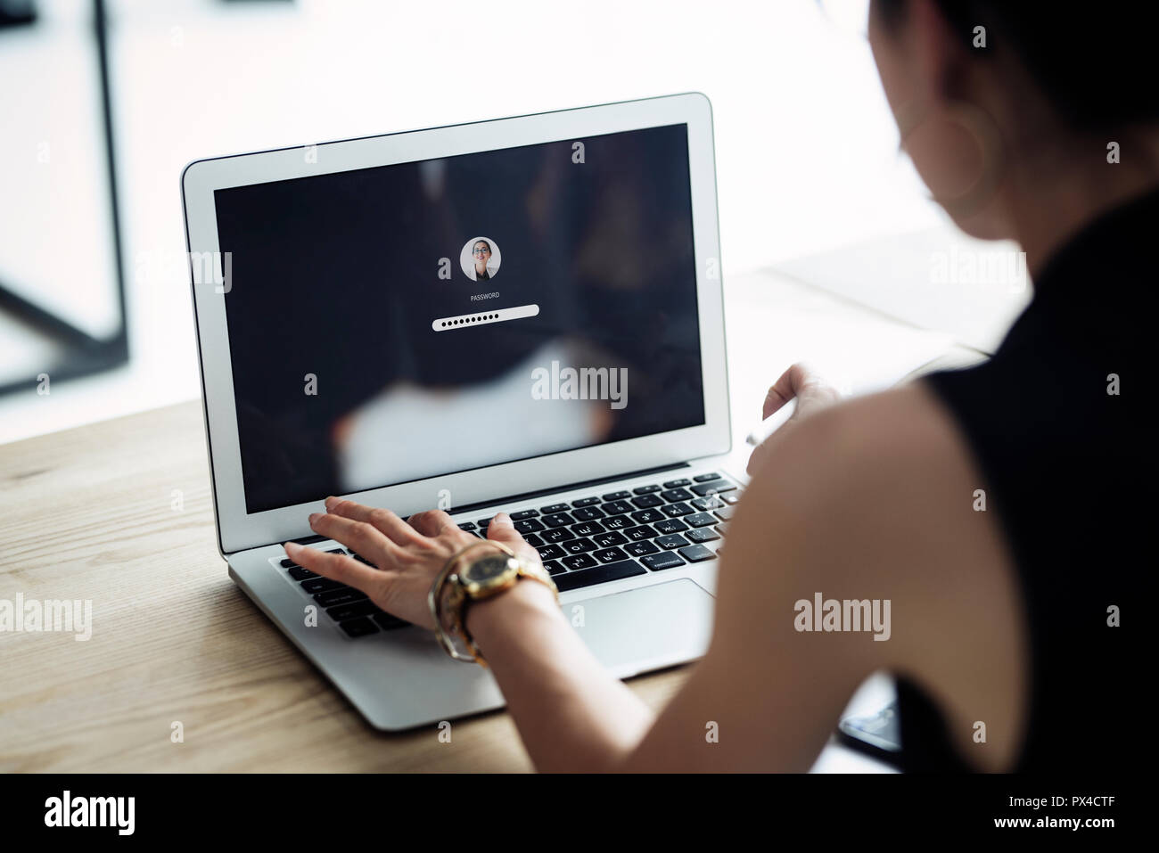 A woman is typing the password in her laptop computer. Communicate ...