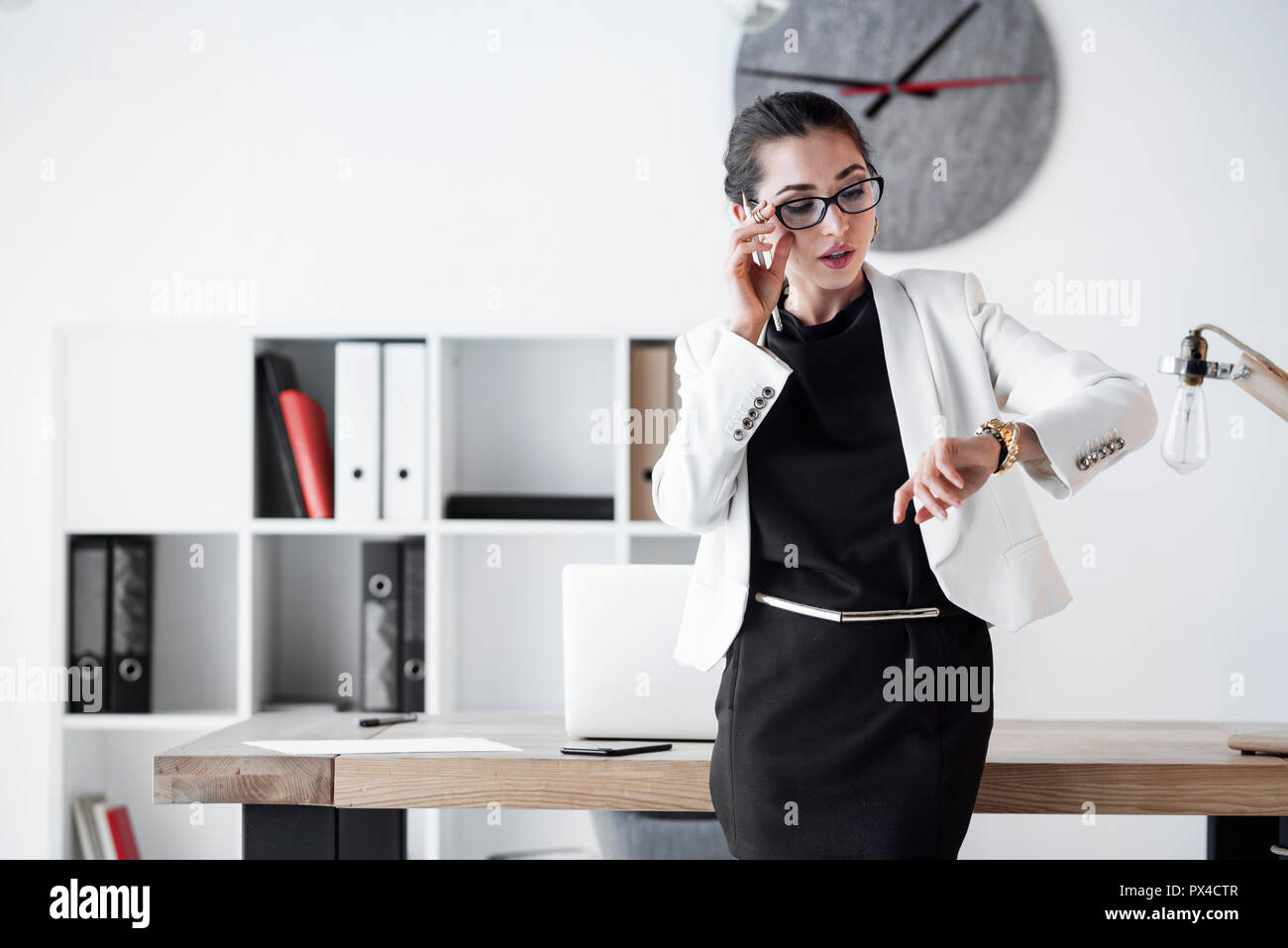 Woman checking clock office hi-res stock photography and images - Alamy
