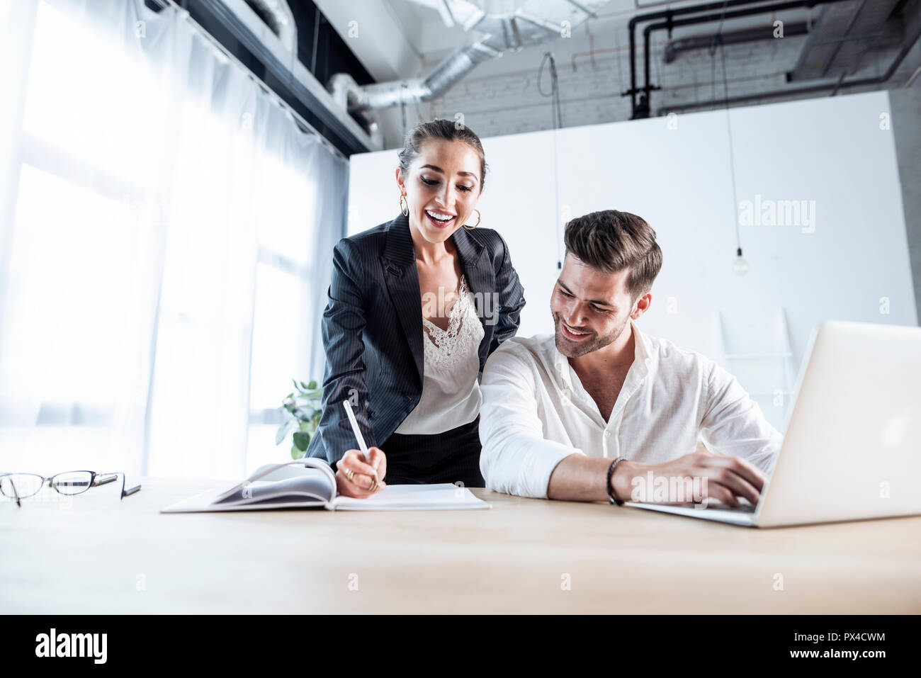 Coworkers on a project working together on the same workstation ...