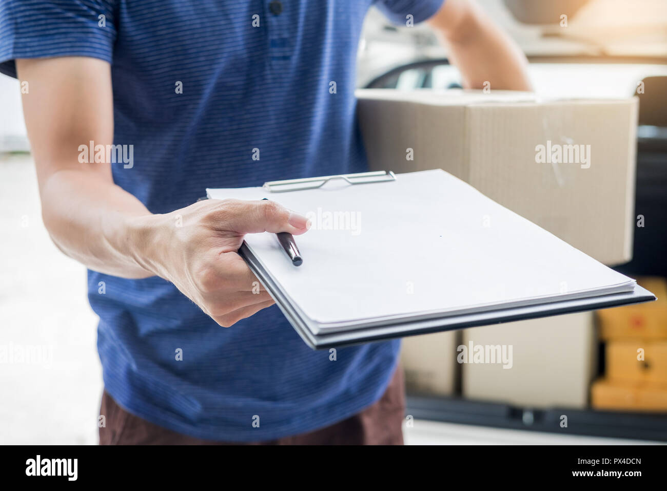 woman courier holding a parcel Shipping Mail appending signature ...