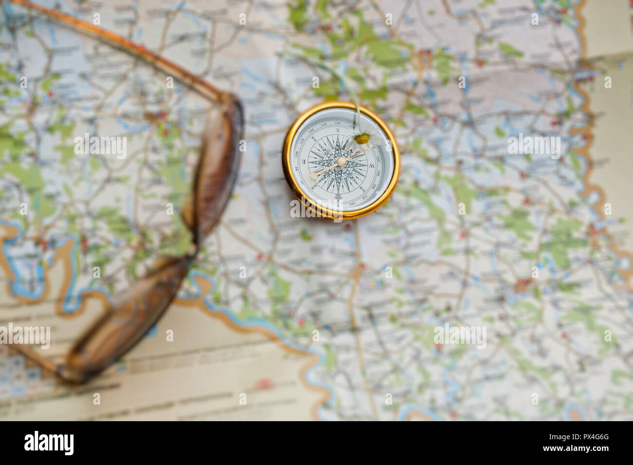 Close-up photo of compass laying on the map next to the sunglasses ...