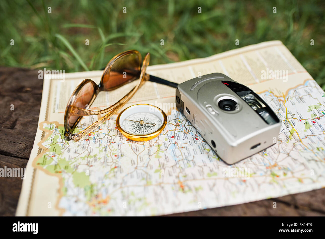 Close-up photo of compass laying on the map next to the camera and ...