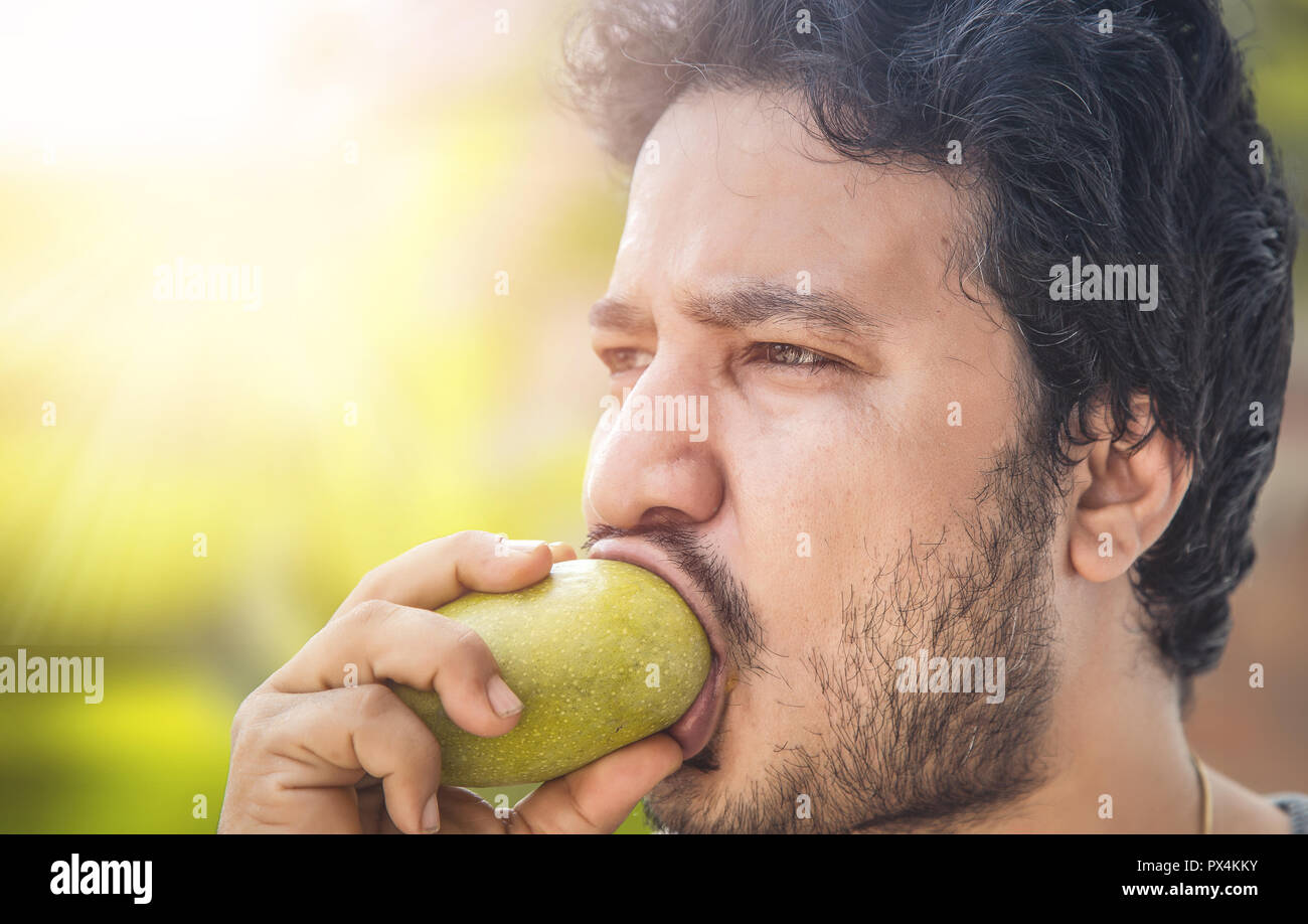 Indian man eating mango Stock Photo - Alamy