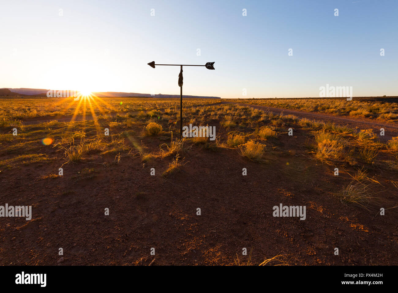 Shash Dine Navajo campsite, AZ, USA. The sun touches the horizon over a ...