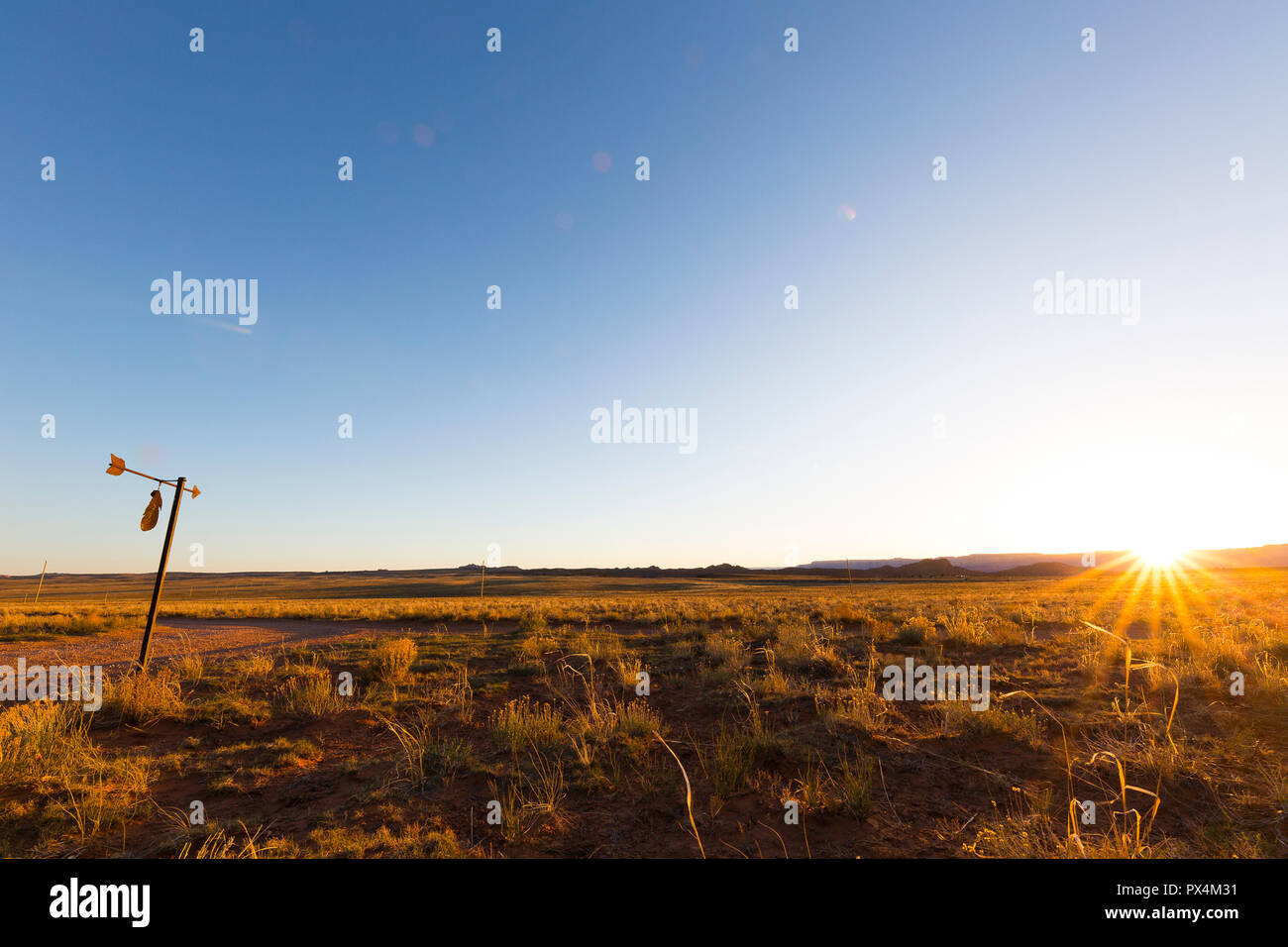 Shash Dine Navajo campsite, AZ, USA. The sun touches the horizon over a ...