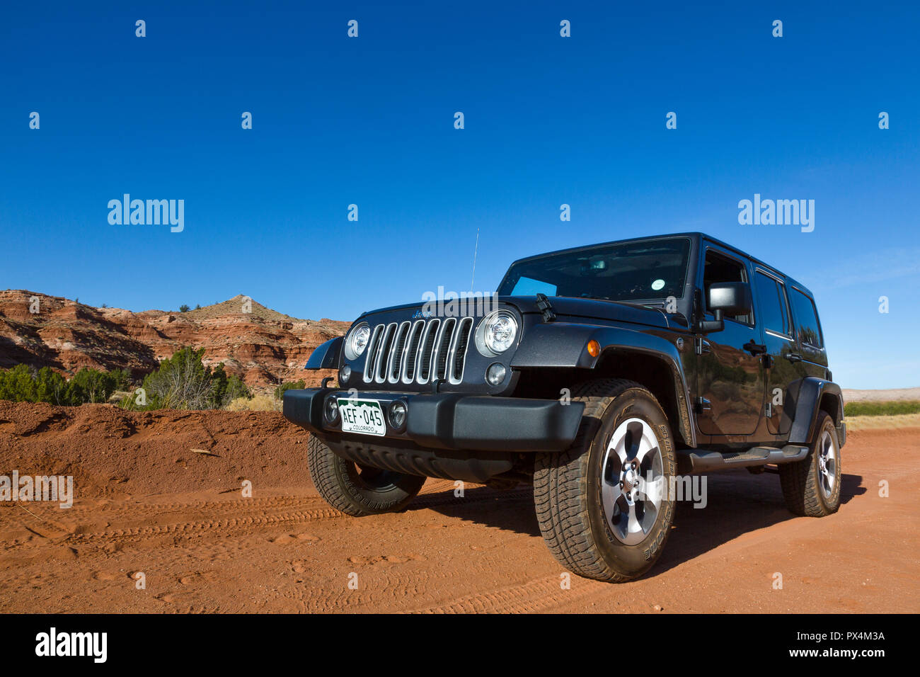 Arizona, USA. Jeep Wranger under blue skies on dirt track in the desert ...
