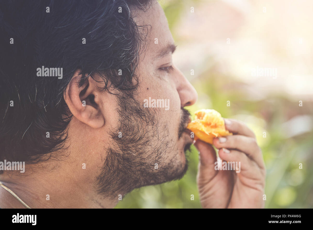 Indian man eating mango Stock Photo - Alamy