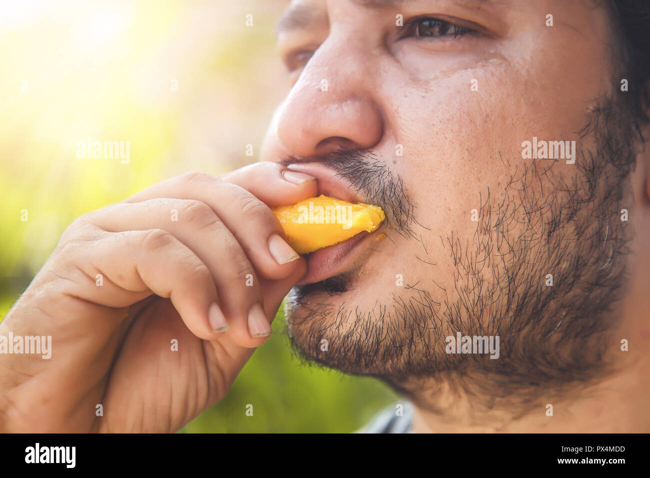 Indian man eating mango Stock Photo - Alamy